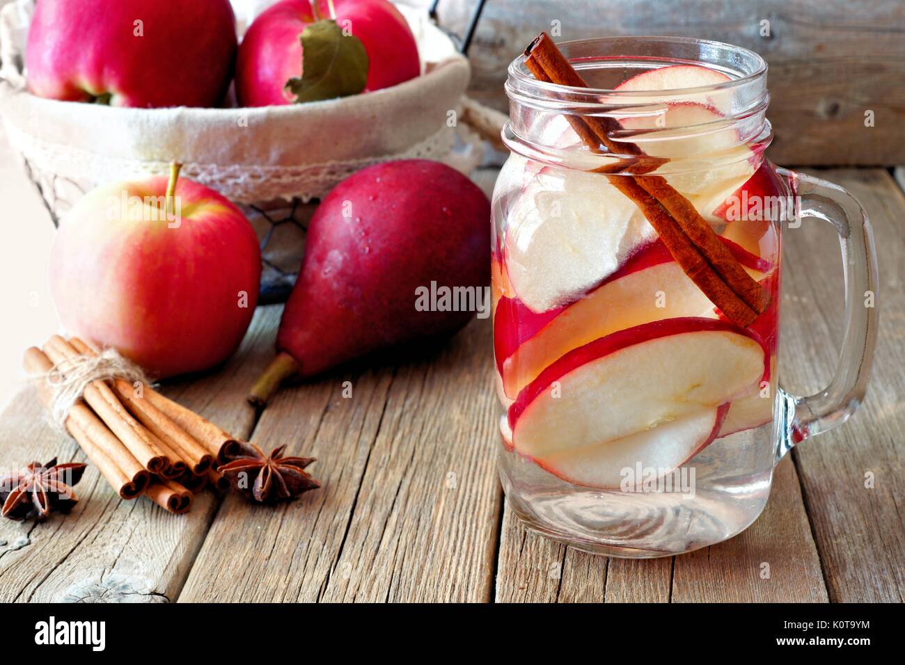 Autumn themed detox water with apple, cinnamon and red pear in a mason ...