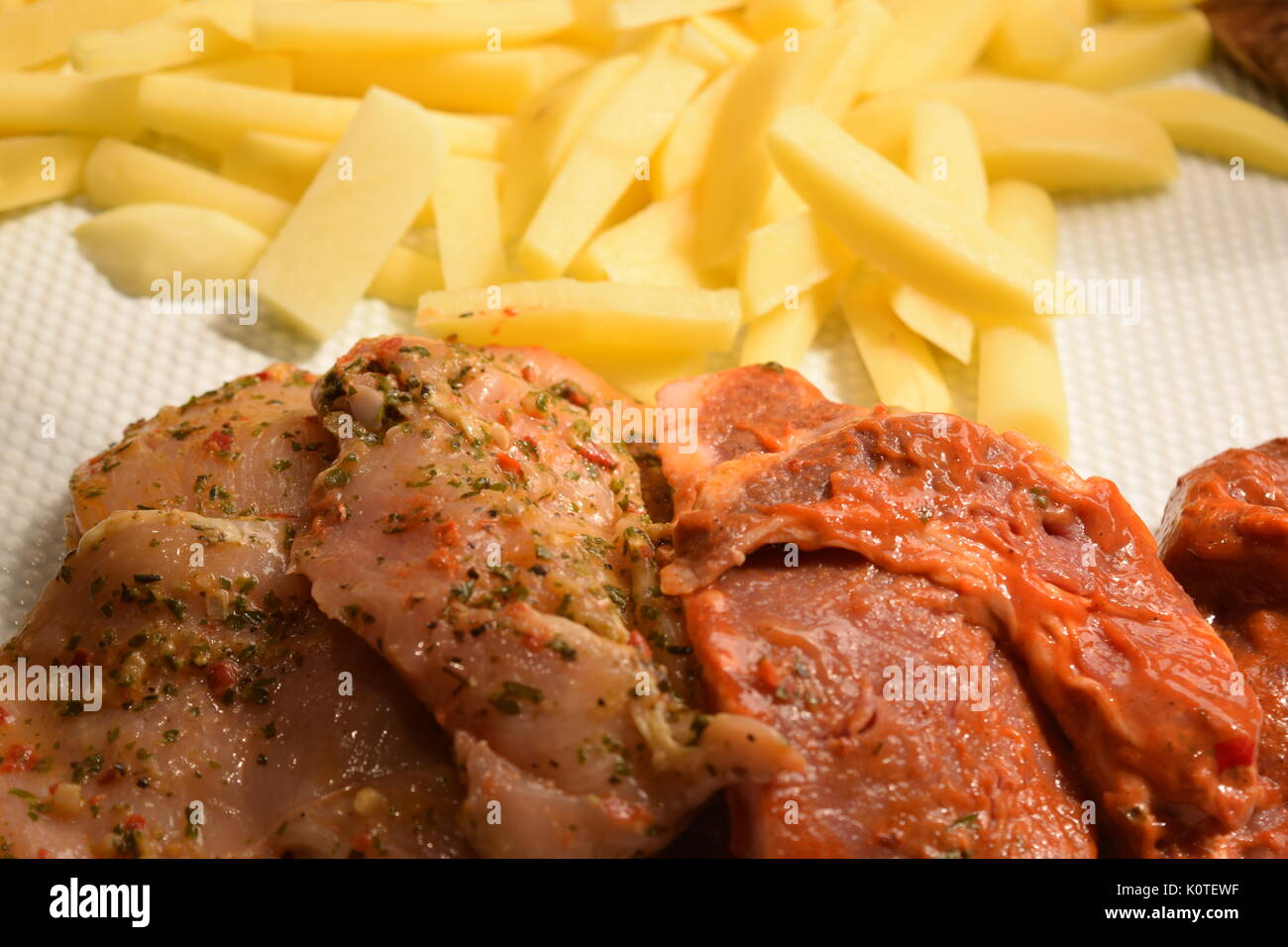 Raw chicken and pork fillet with chips Stock Photo - Alamy