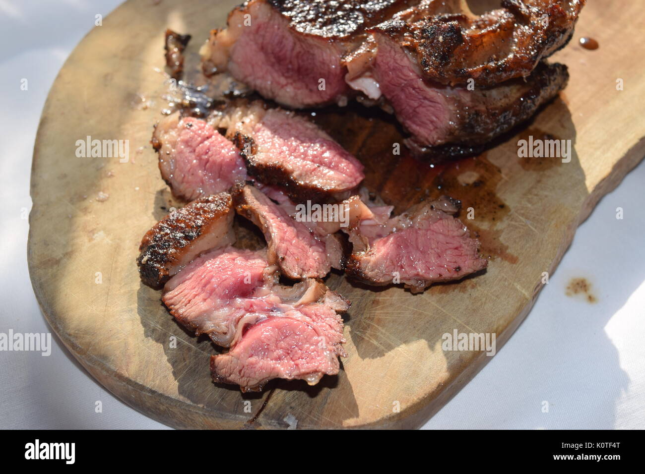 Medium rare meat on a wooden board Stock Photo - Alamy