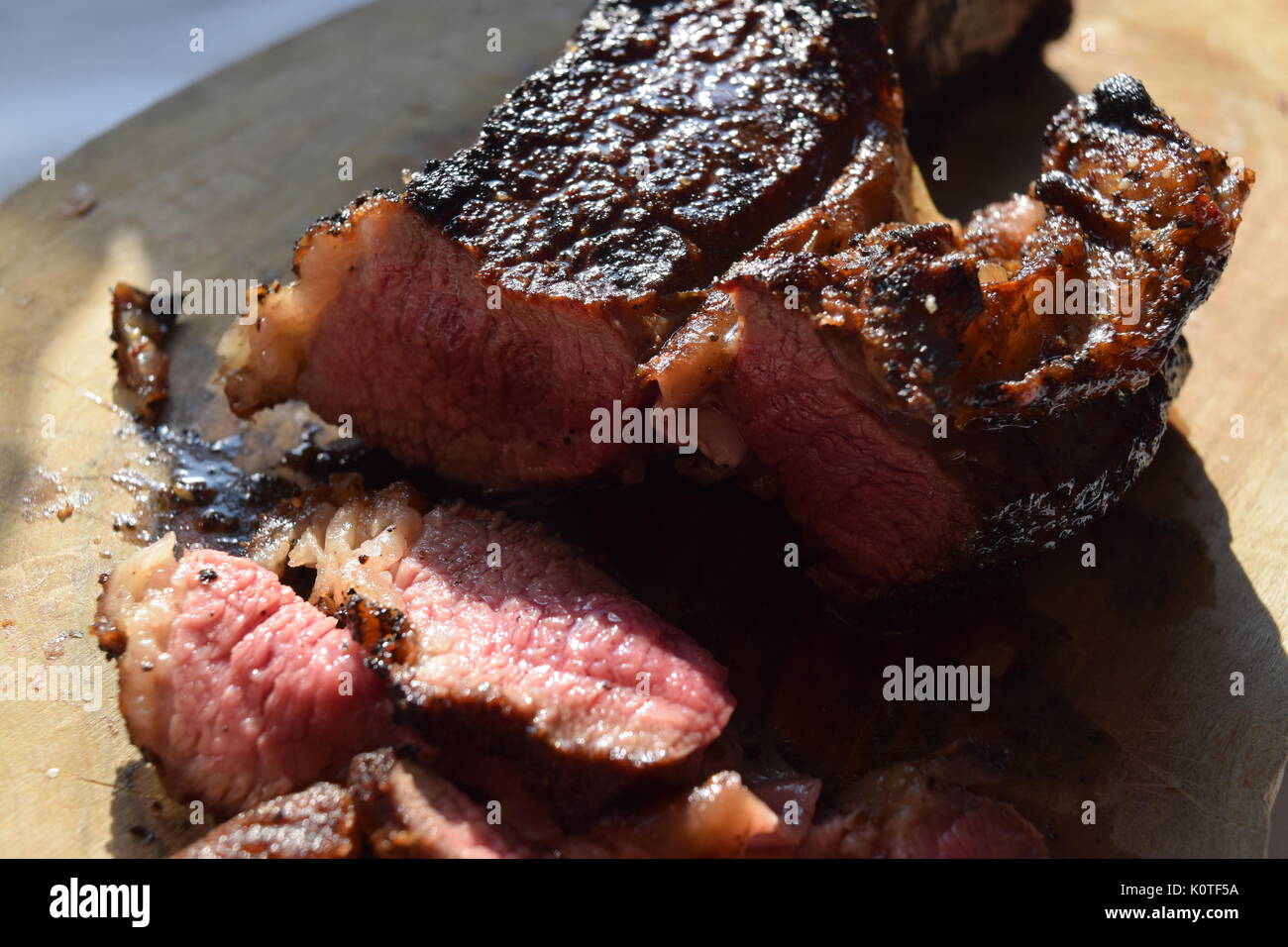 Close up of medium rare meat on a wooden boar Stock Photo - Alamy