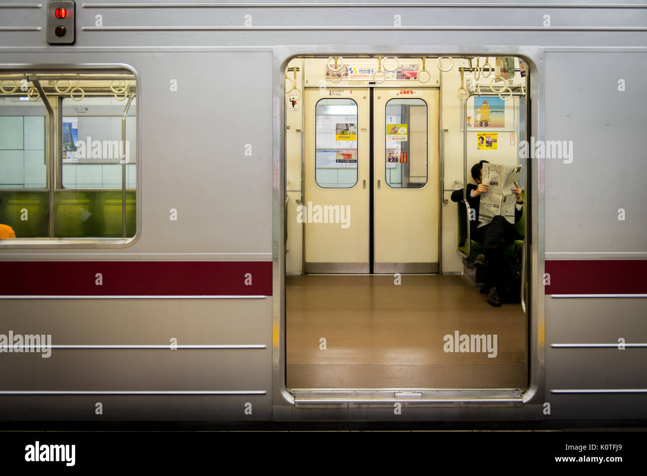 Man reading newspaper on train Stock Photo - Alamy
