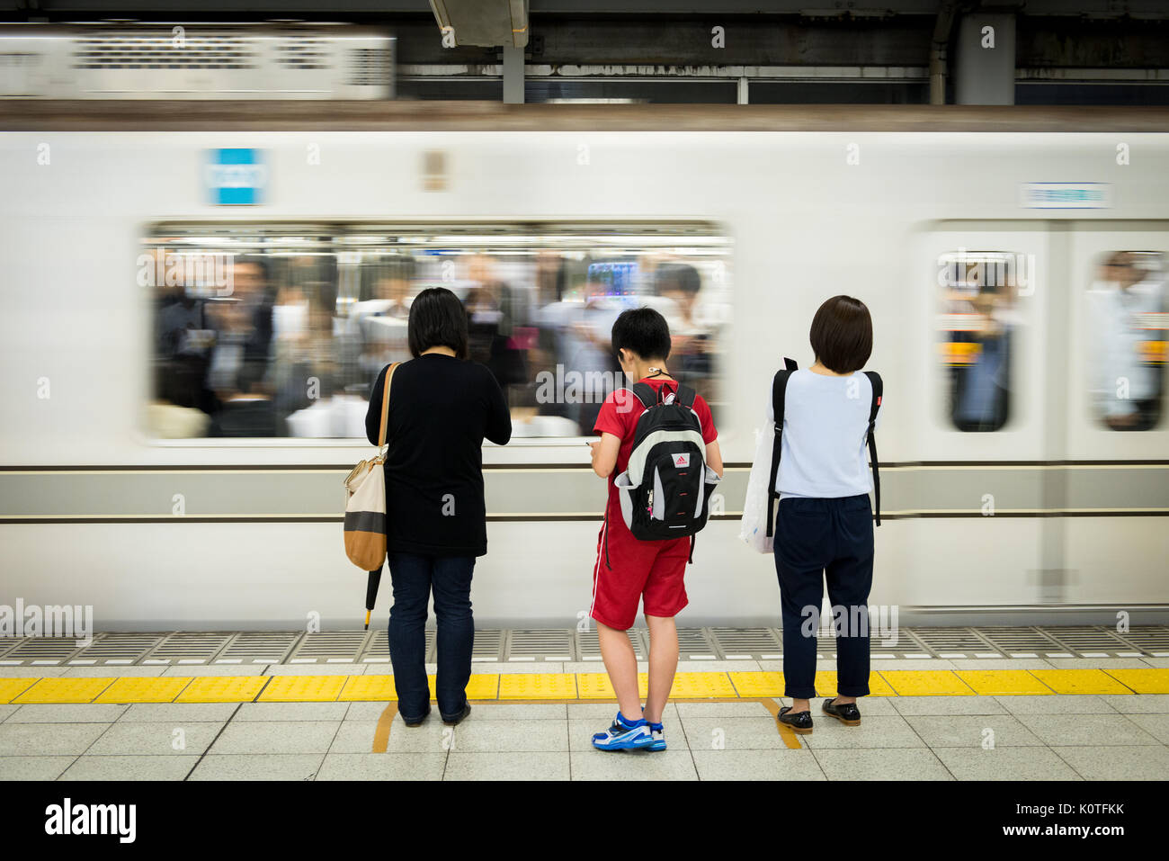 Commuters in Tokyo waiting for subway train Stock Photo - Alamy