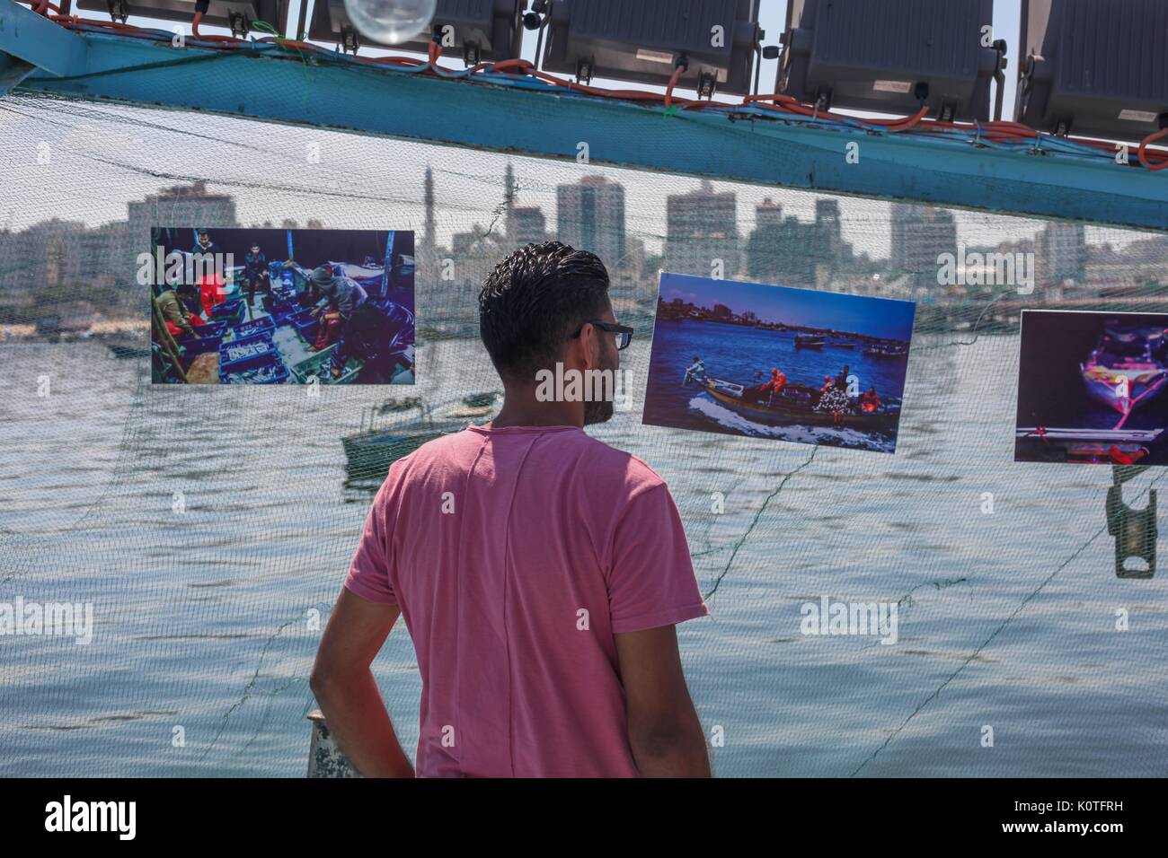 Palestinians attend a photo gallery on fishing boat, in Gaza seaport ...