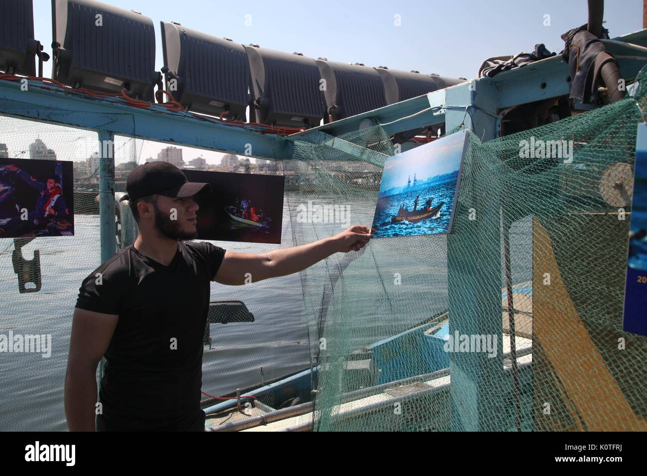 Palestinians attend a photo gallery on fishing boat, in Gaza seaport ...