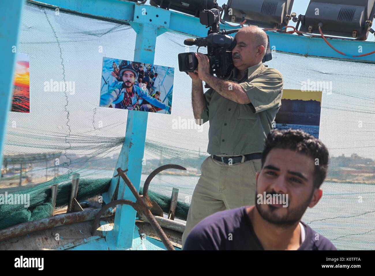 Palestinians attend a photo gallery on fishing boat, in Gaza seaport ...