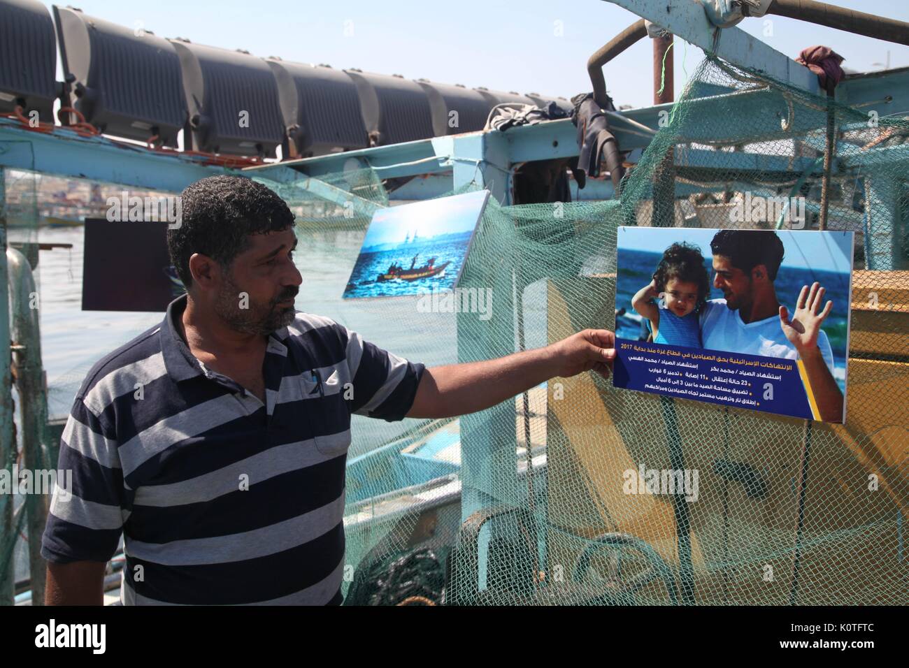 Palestinians attend a photo gallery on fishing boat, in Gaza seaport ...