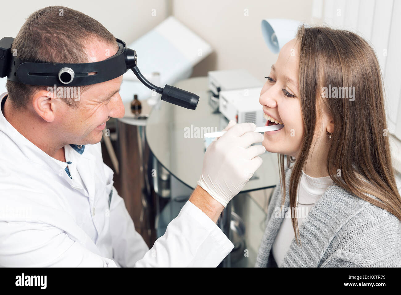 Doctor ENT checking ear with otoscope to woman patient. private clinic ...