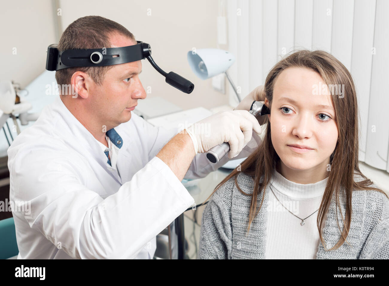ENT physician looking into patient's ear with an instrument. private ...