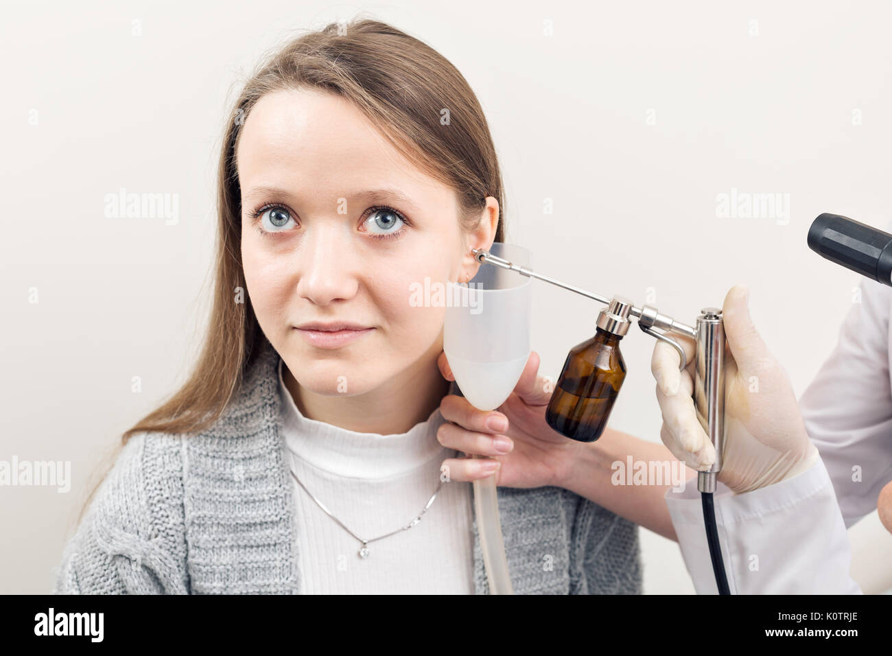 ENT physician looking into patient's ear with an instrument. private ...