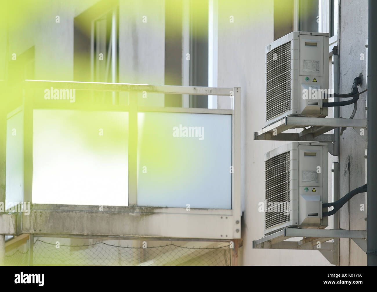 Two air conditioning units on the side of a residential building in ...