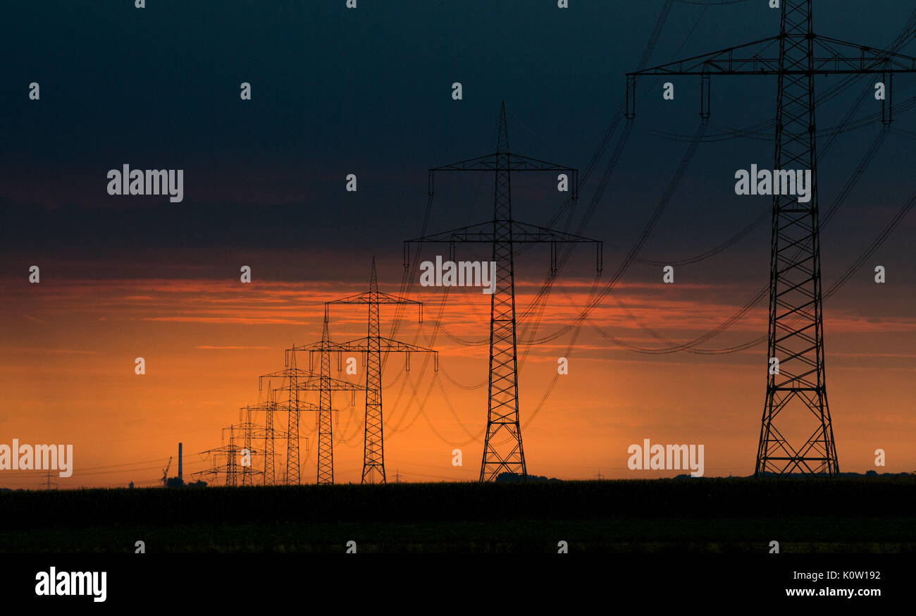 The rising sun flooding with a warm light the sky over high voltage ...