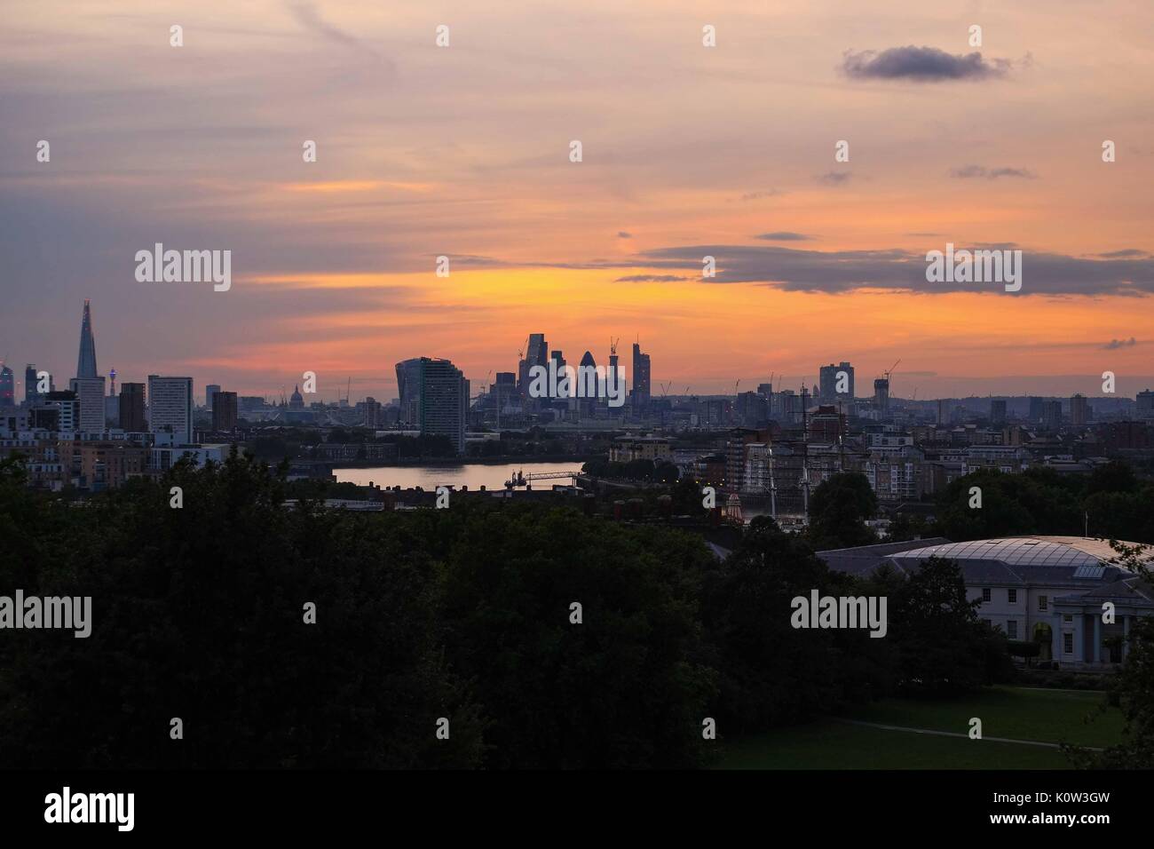 London, UK. 24th August, 2017. A man takes a photograph of the sunset ...