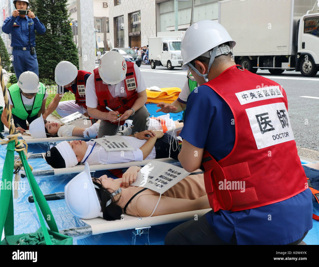 Tokyo, Japan. 25th Aug, 2017. Injured persons receive first aid from ...