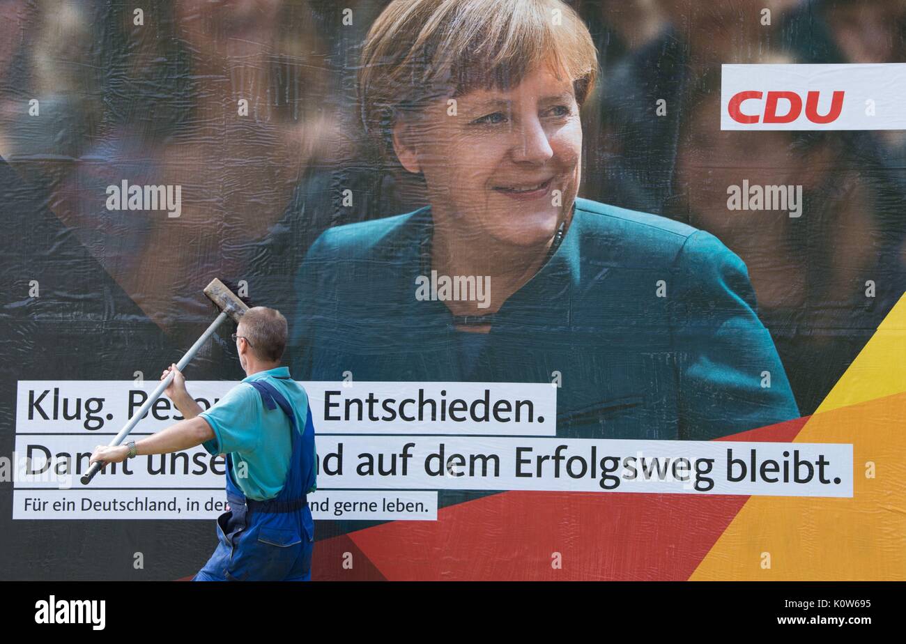 Dresden, Germany. 25th Aug, 2017. A man pasting on a wall a Bundestag ...