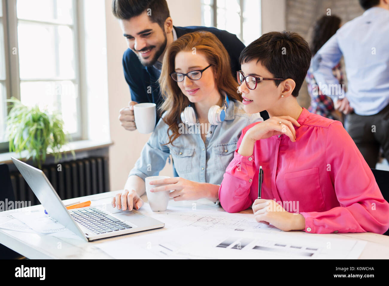 Group of young architects working on laptop Stock Photo - Alamy