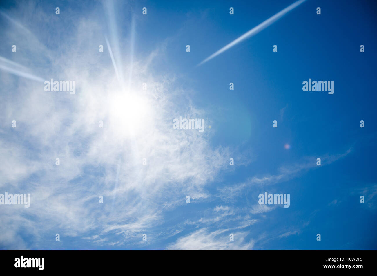 Sun with lens flare, on blue sky background. Glare from the bright sun ...