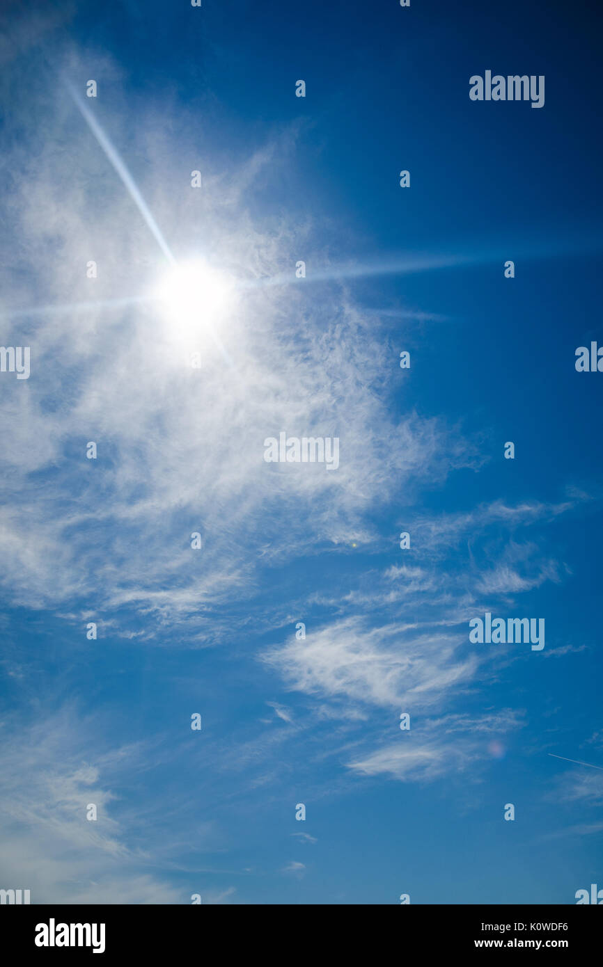bright blue sky with the sun causing lens flare. Glare from the bright ...