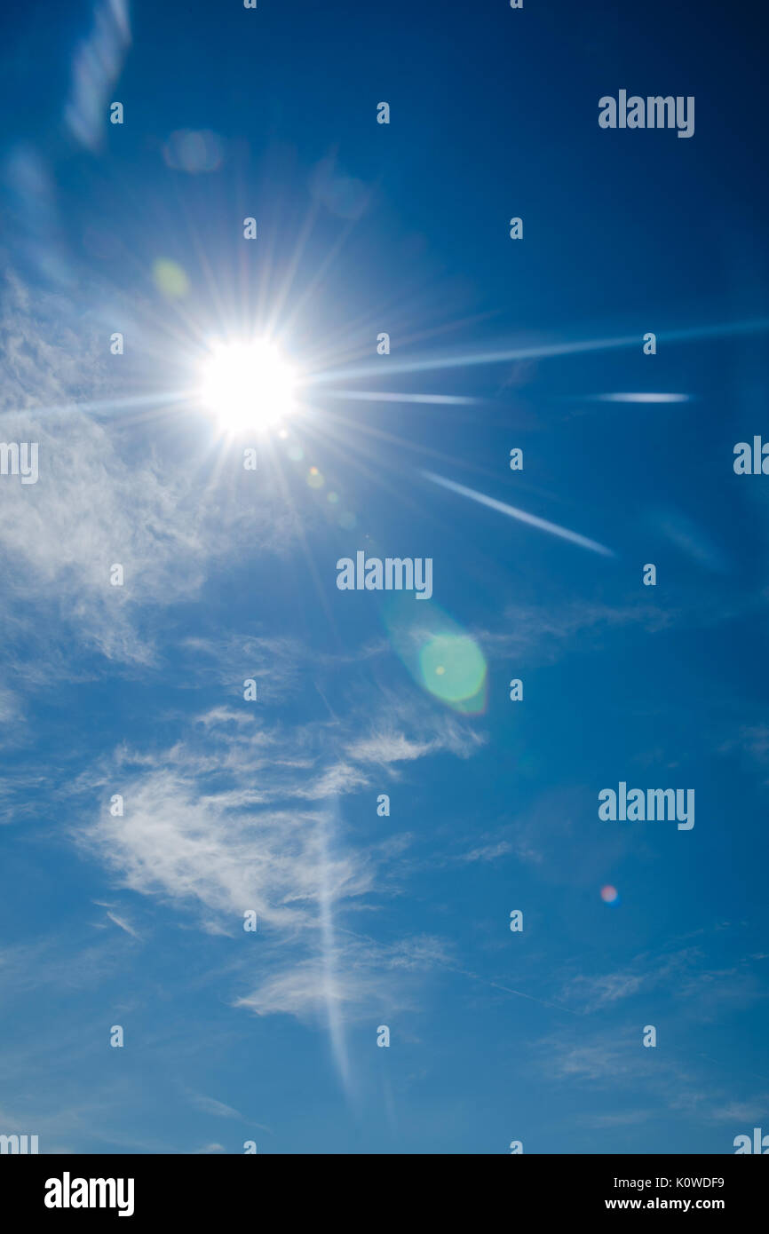 bright blue sky with the sun causing lens flare. Glare from the bright ...