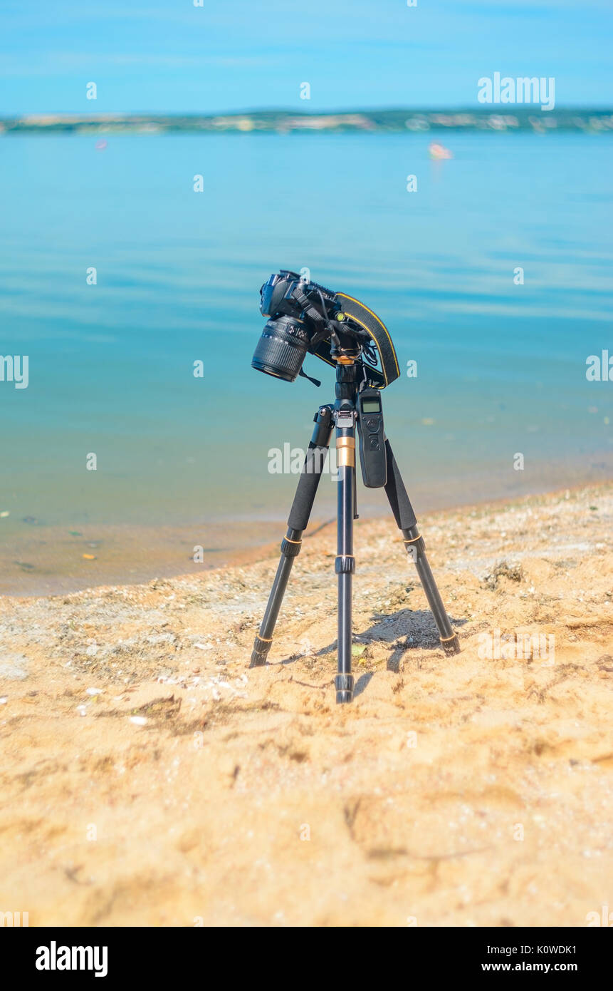 Camera on a tripod near the seaside removes of seashells on the sand ...