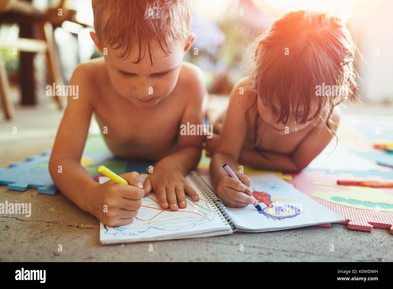 Little boy and girl drawing with crayons Stock Photo - Alamy