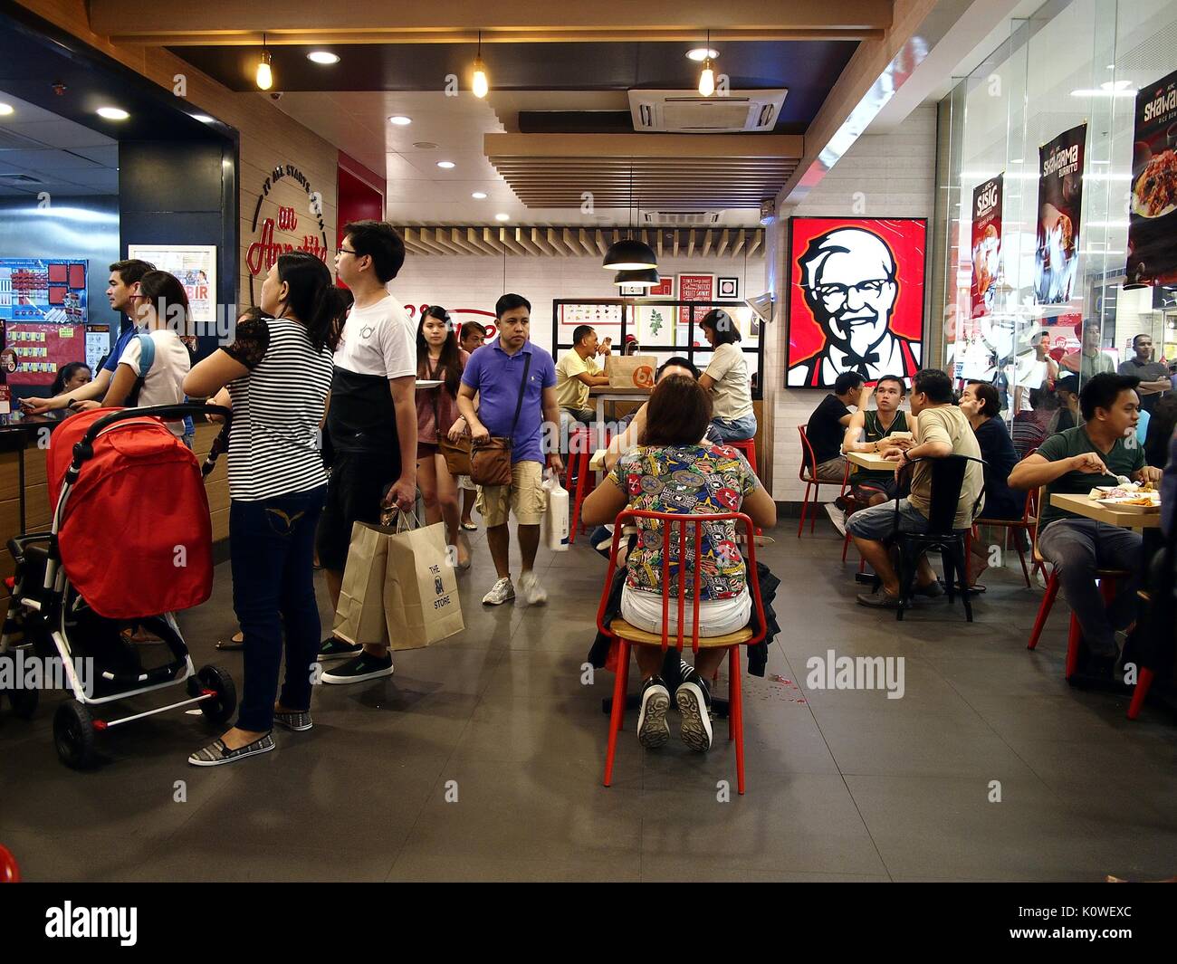 PASIG CITY, PHILIPPINES - AUGUST 20, 2017: Customers eating inside a ...