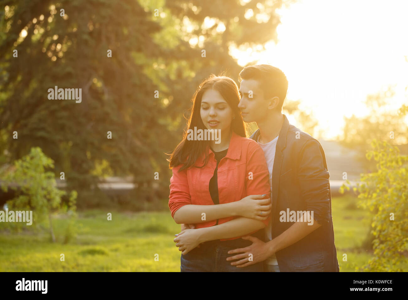 Date of teenagers. The guy hugs her friend from behind. Human faces are ...
