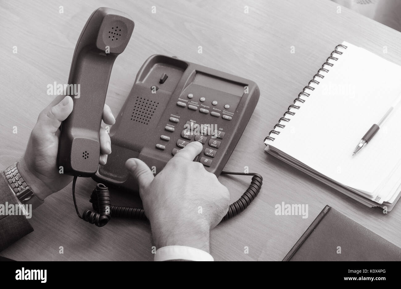 The businessman dials the number on the landline phone, holds the ...