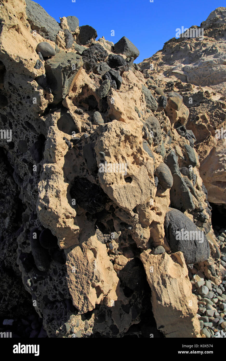 Conglomerate rock with volcanic bombs embedded in sediment, Playa de ...
