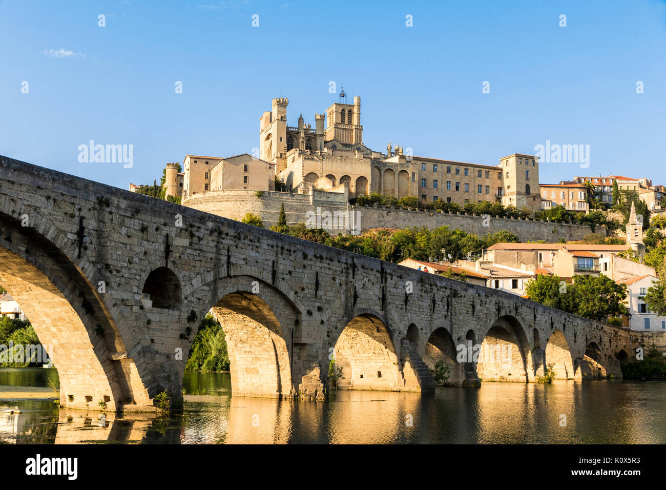 Views at sunset of the French city of Beziers, with trees and the old ...