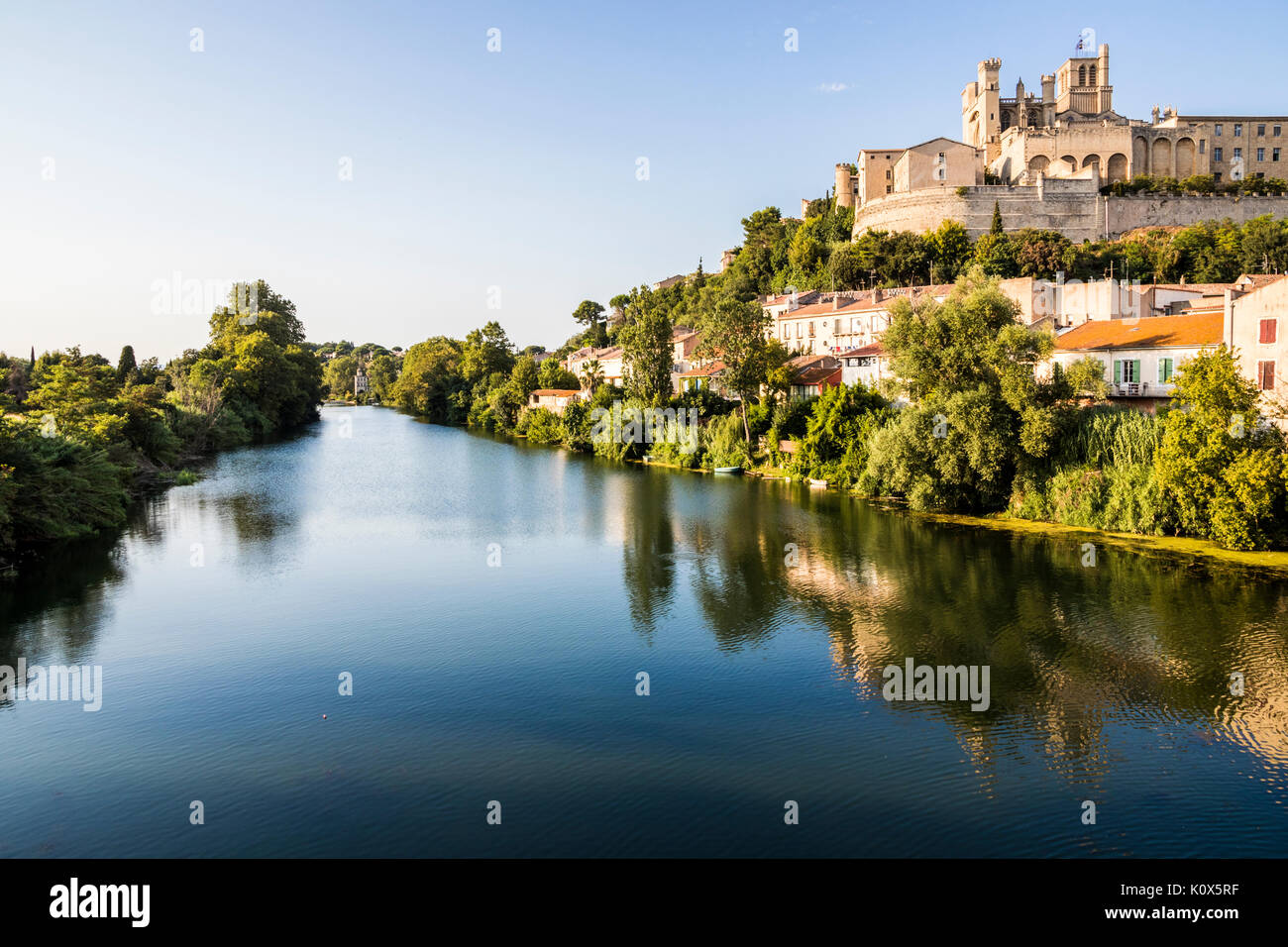 Views at sunset of the French city of Beziers, with trees, the river ...