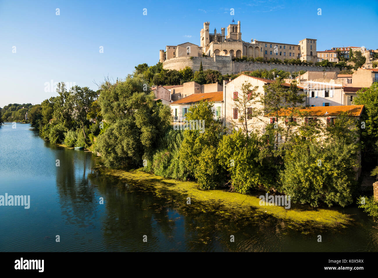 Views at sunset of the French city of Beziers, with trees, the river ...