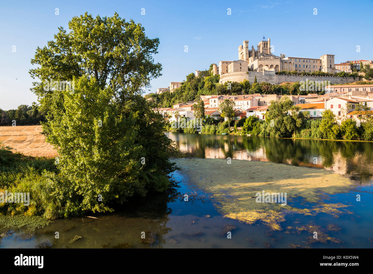 Views at sunset of the French city of Beziers, with trees, the river ...