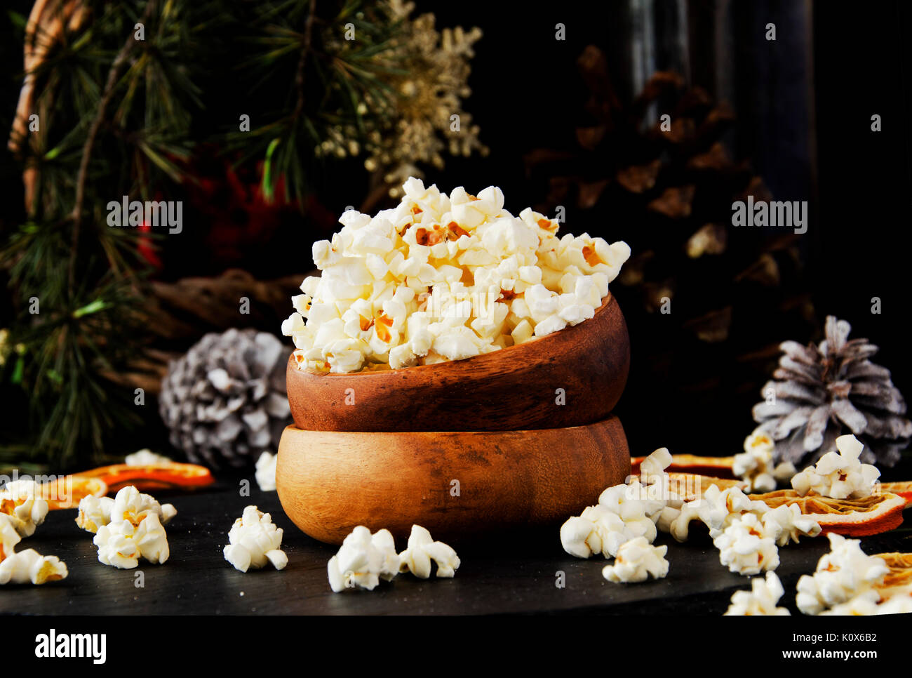popcorn in a wooden plate on the background of Christmas trees and ...