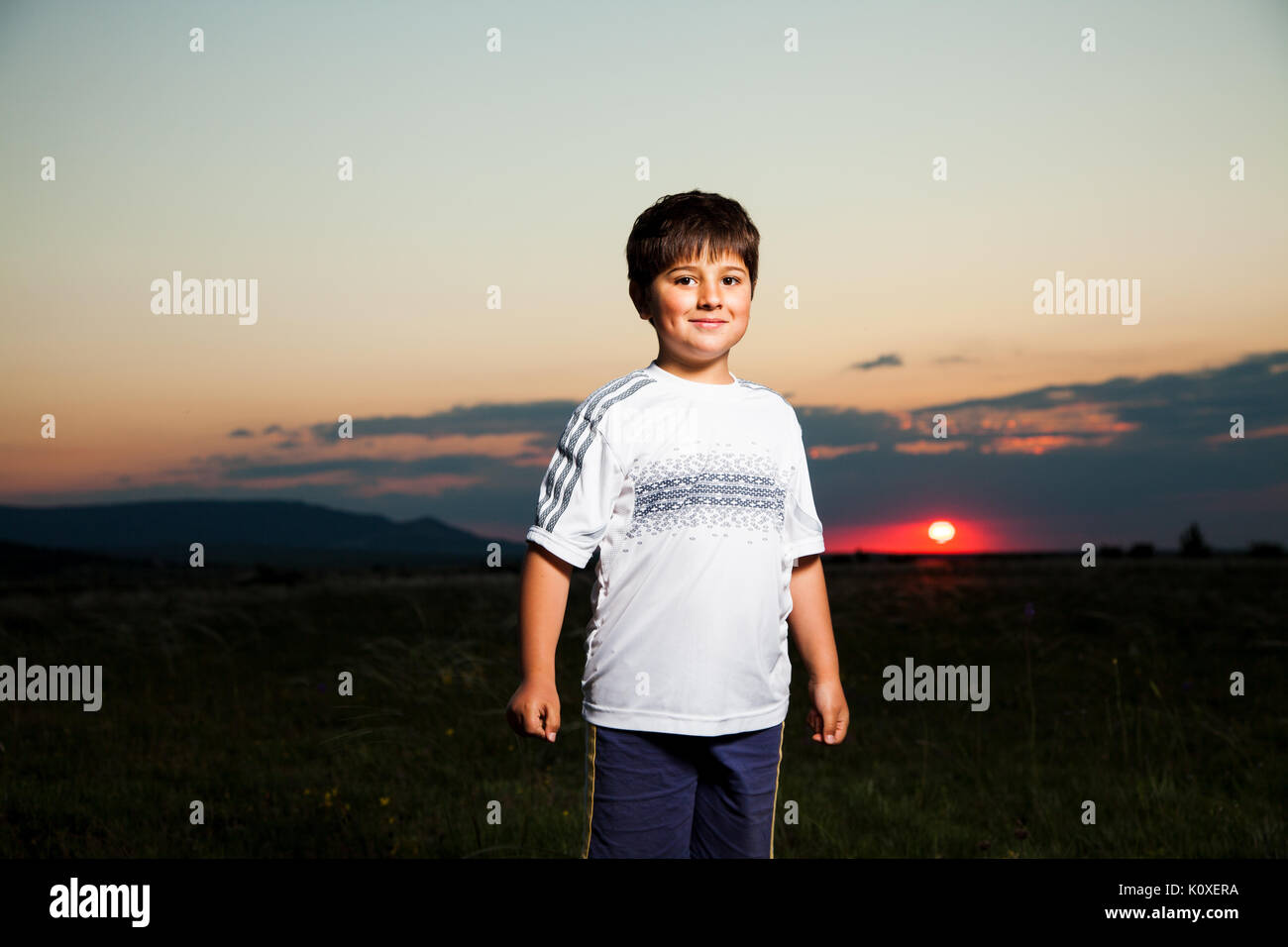 Brave boy is smiling against the dusk with sun Stock Photo - Alamy