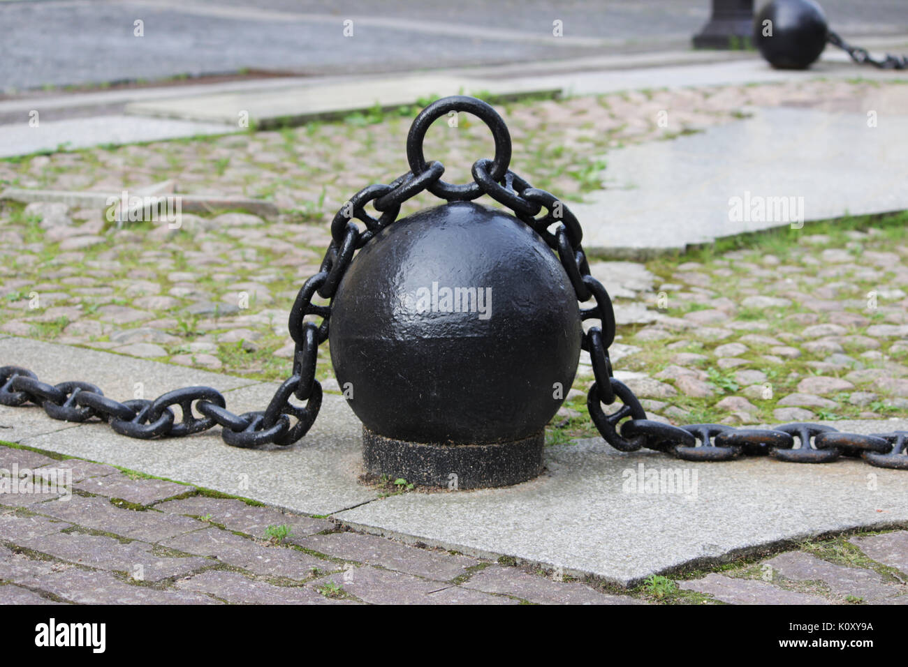 Black metal chain with large links and round heavy weights lies on ...