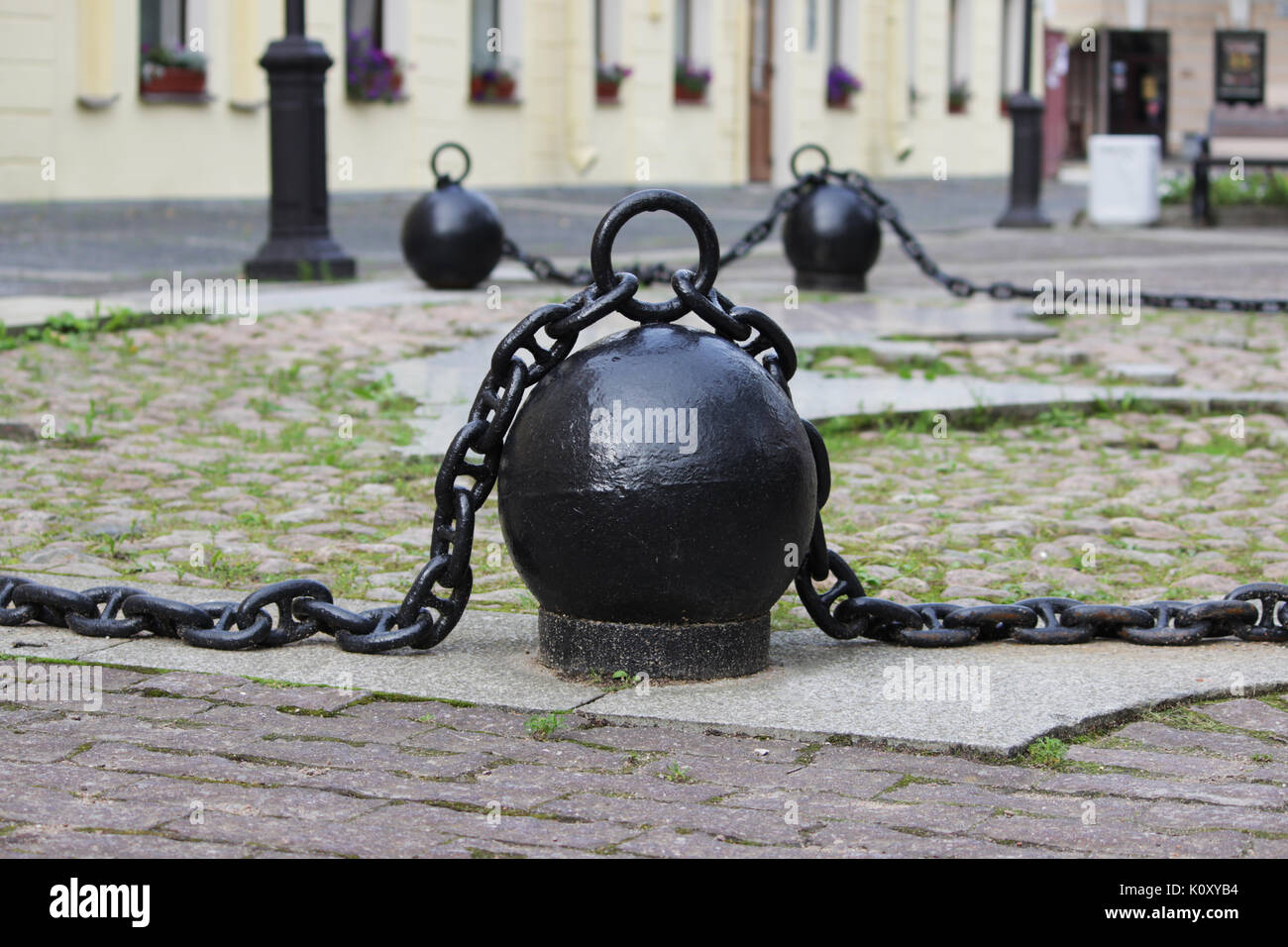 Black metal chain with large links and round heavy weights lies on ...