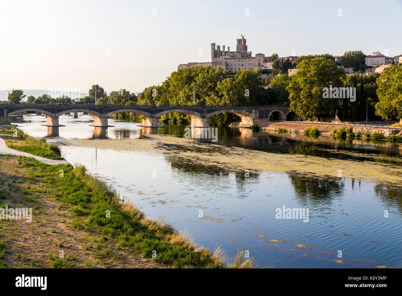 Views at sunset of the French city of Beziers, with trees and one of ...