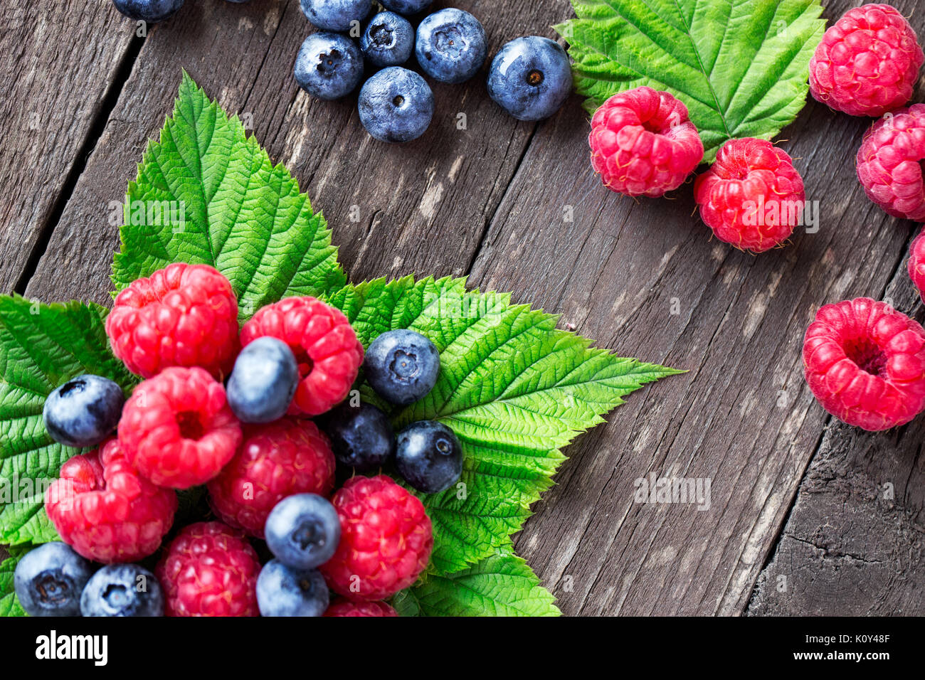 raspberry, blueberry with leaves close up background Stock Photo - Alamy