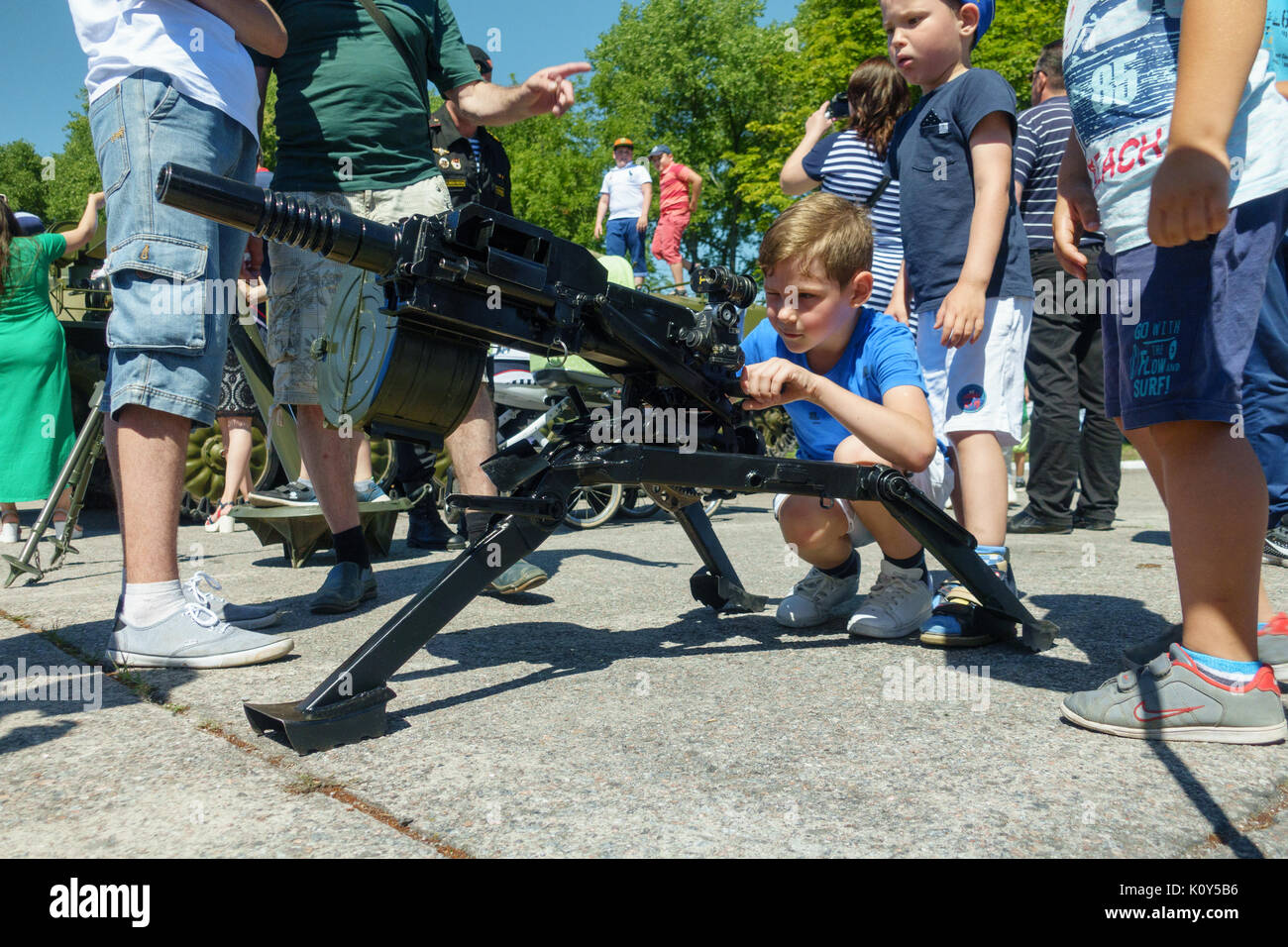 Unidentified children age 5-10 years try real weapons Stock Photo - Alamy