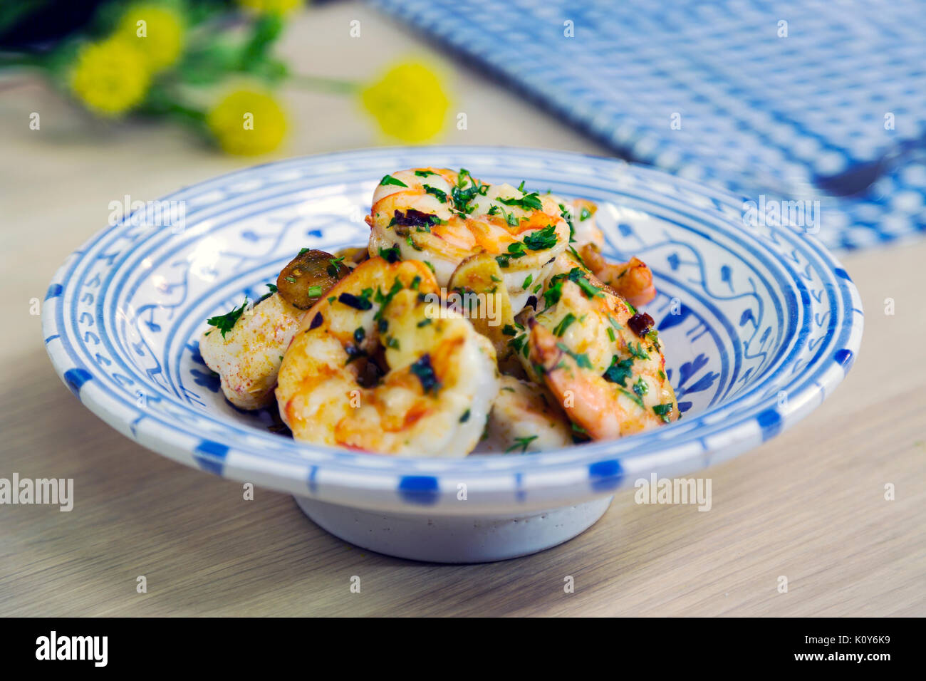 King prawns are grilled and served with parsley and melted butter in a ...