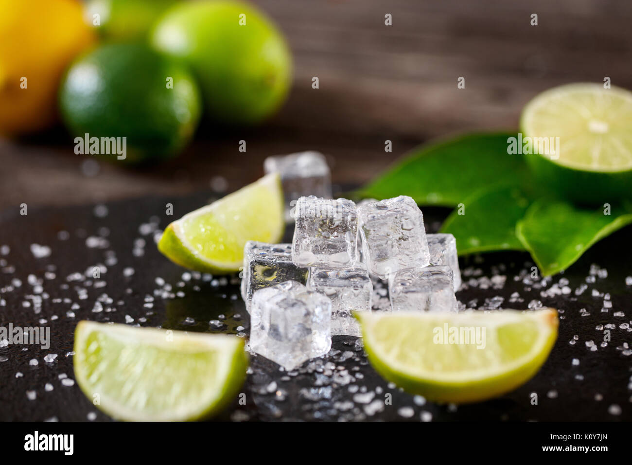 ice cube and lime slice on black table background Stock Photo - Alamy