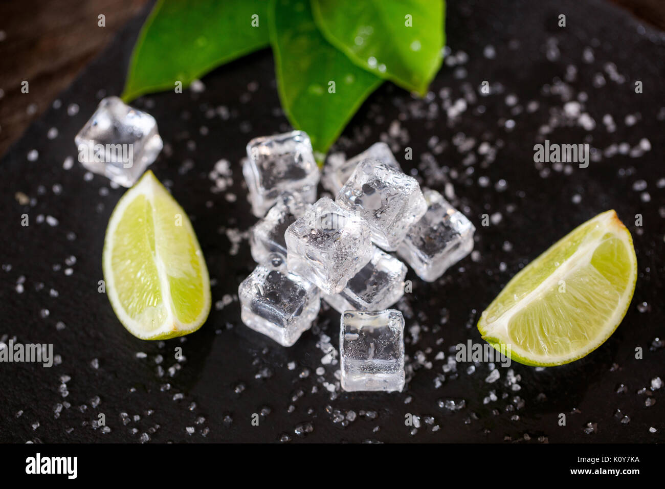 ice cube with lime slices and salt on dark table background Stock Photo ...