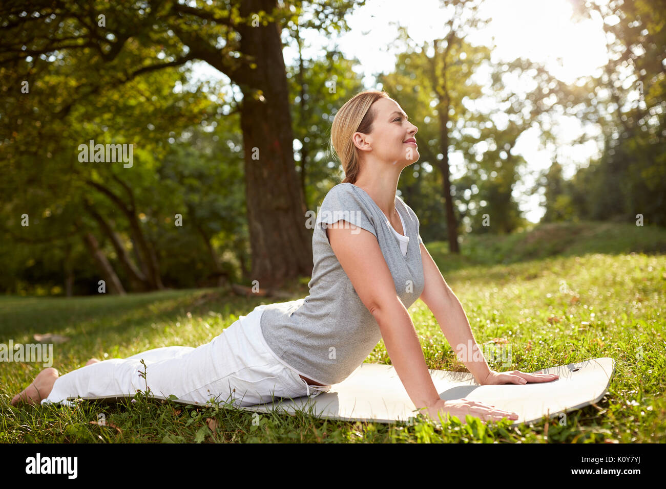 Lady exercising and stretching in green nature on summer Stock Photo ...