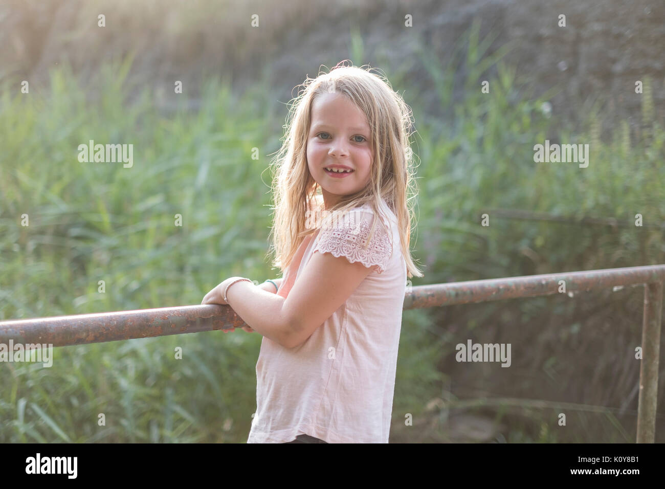 Little girl standing on a bridge by a river Stock Photo - Alamy