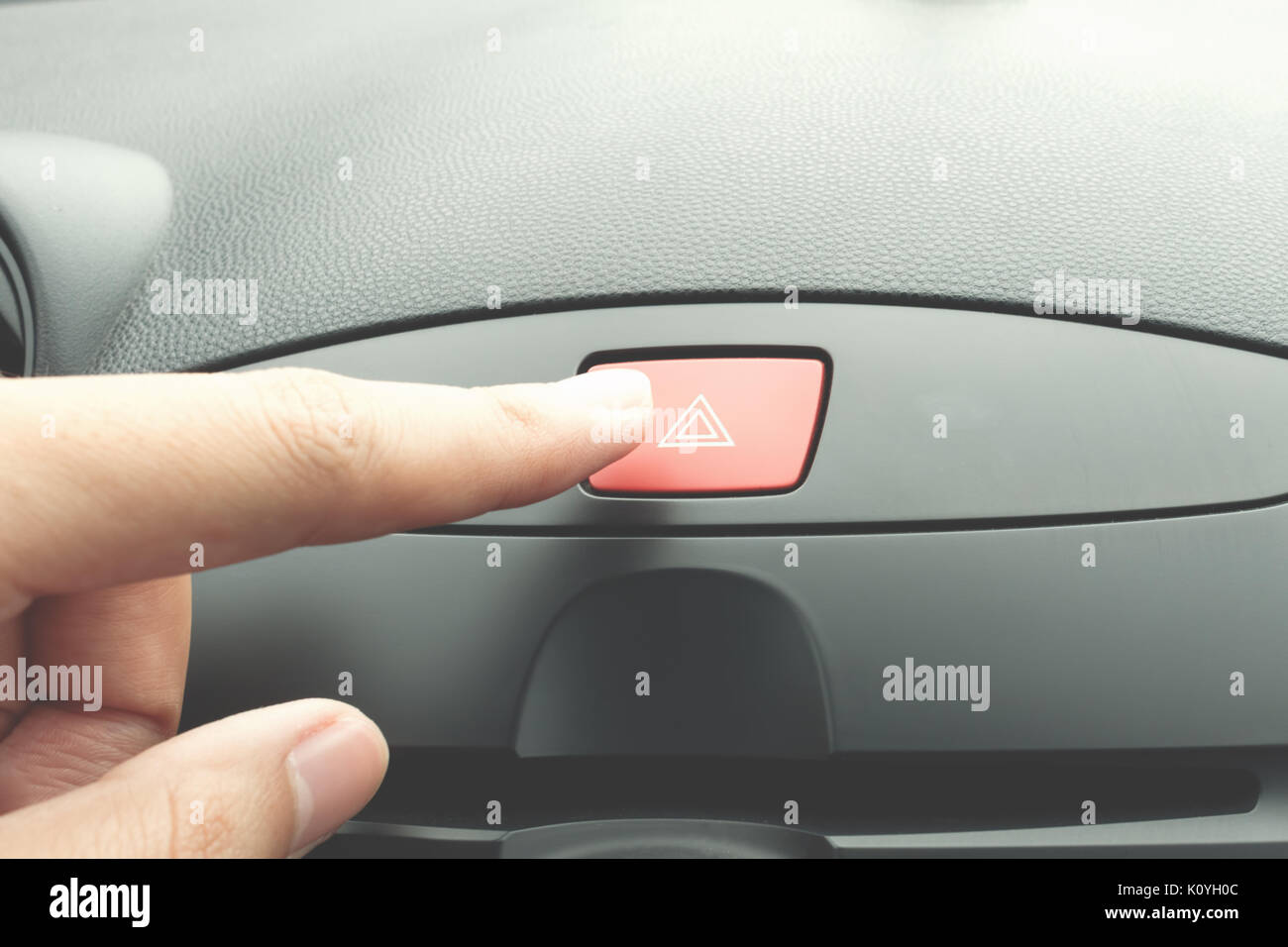 Finger pressing car emergency button Stock Photo - Alamy