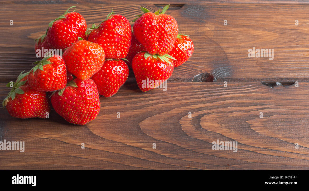 multiple strawberry's on a wooden table in a corner Stock Photo - Alamy