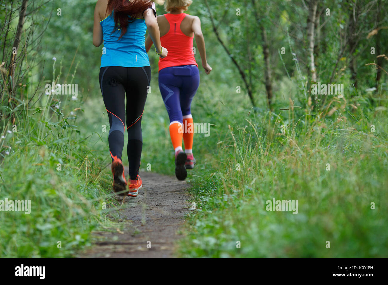 Male and female runners running in forest hi-res stock photography and ...