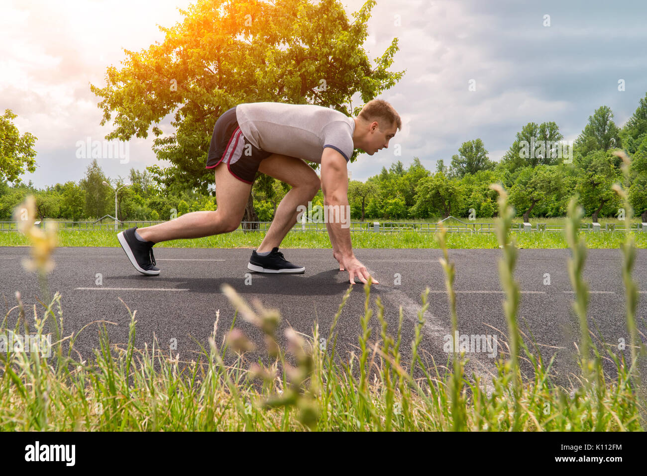 The man is running around the stadium. Training outdoors. Side view ...