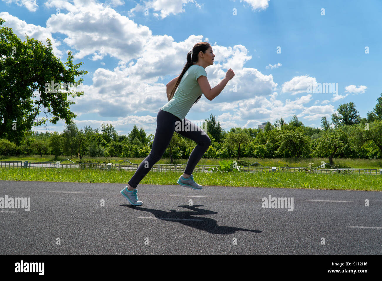 The girl is running around the stadium. Training outdoors. From the ...