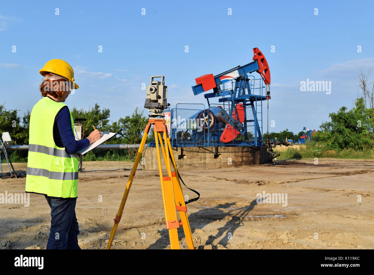 Surveyor at work and crude oil pump in background Stock Photo - Alamy